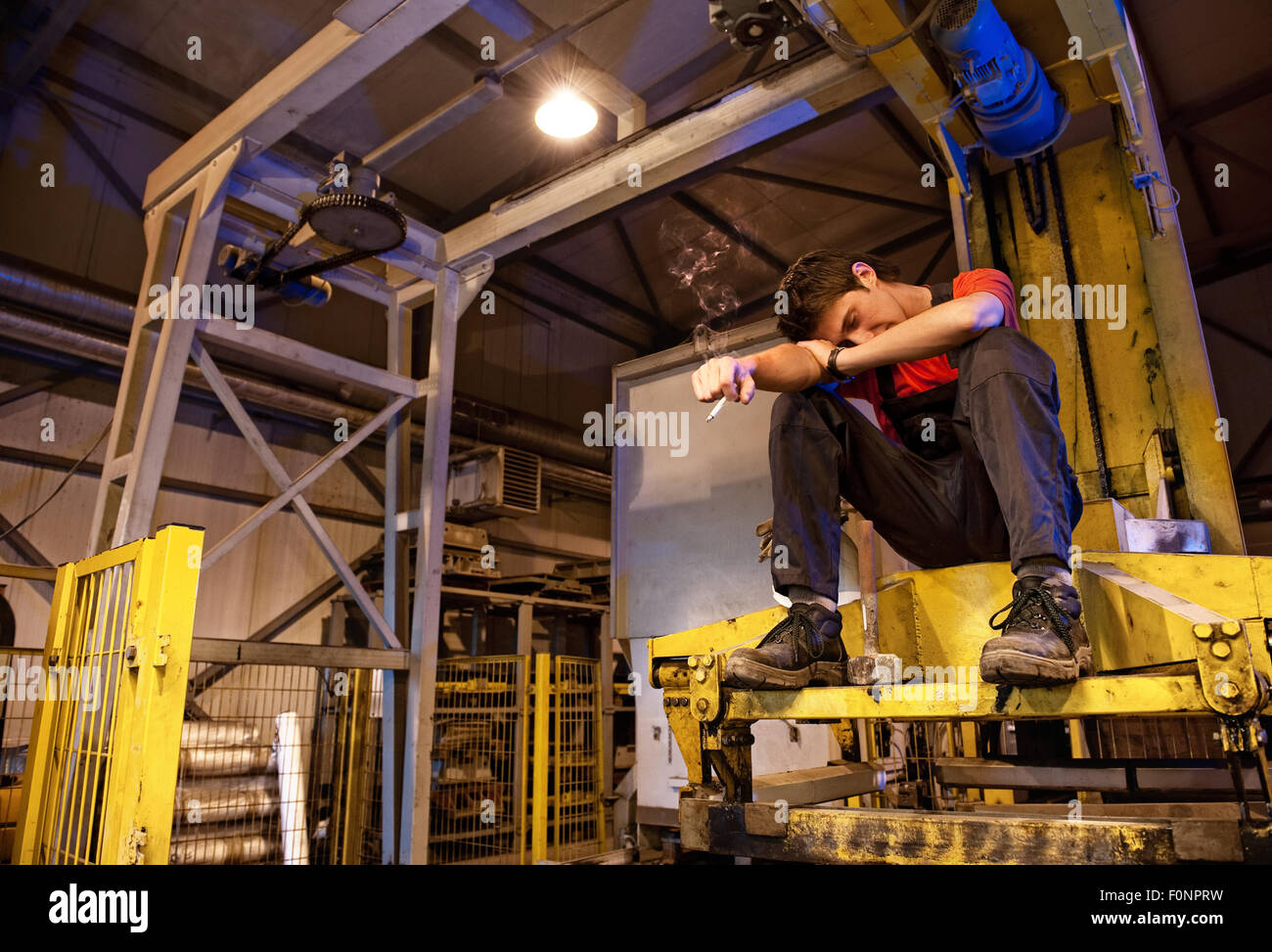 Exhausted factory worker smoking Stock Photo - Alamy