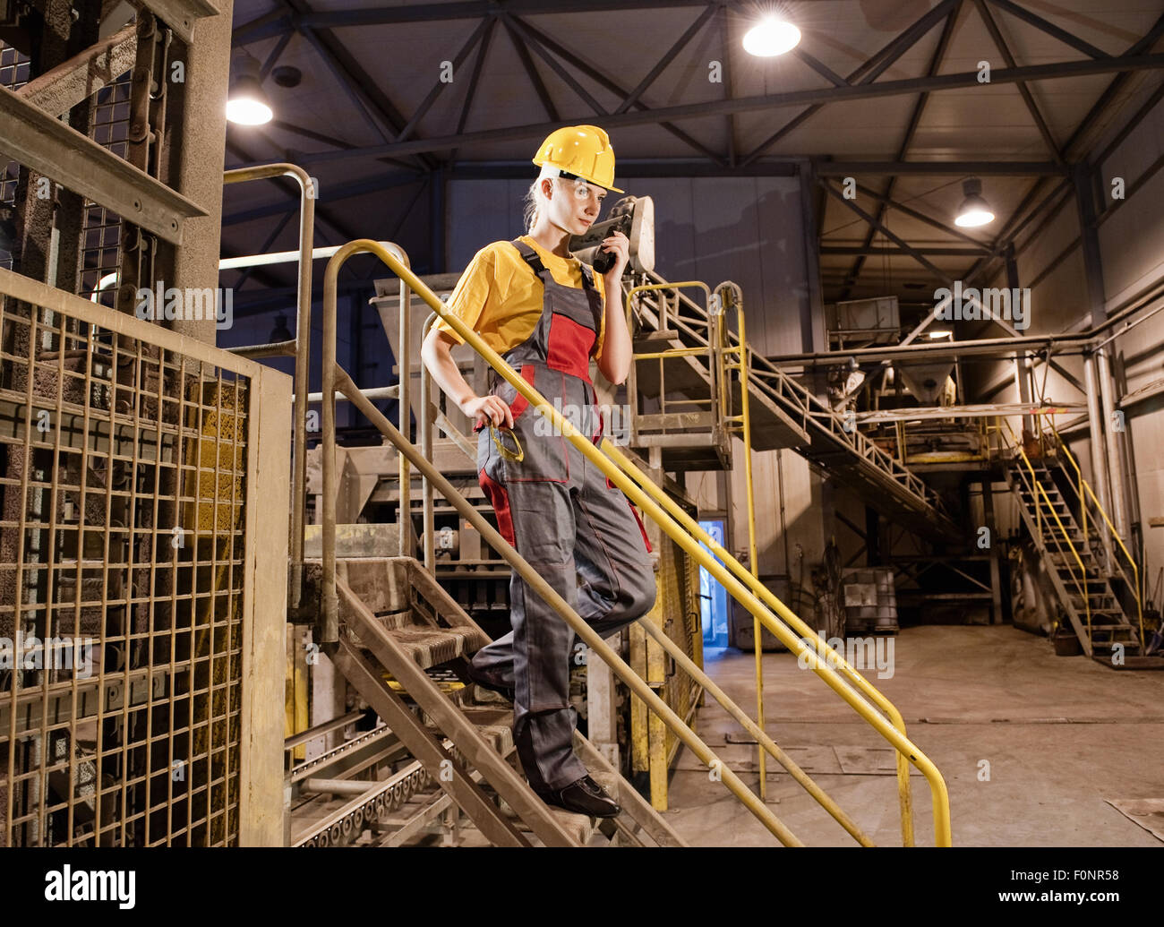 Female factory worker talking on the radio phone Stock Photo - Alamy