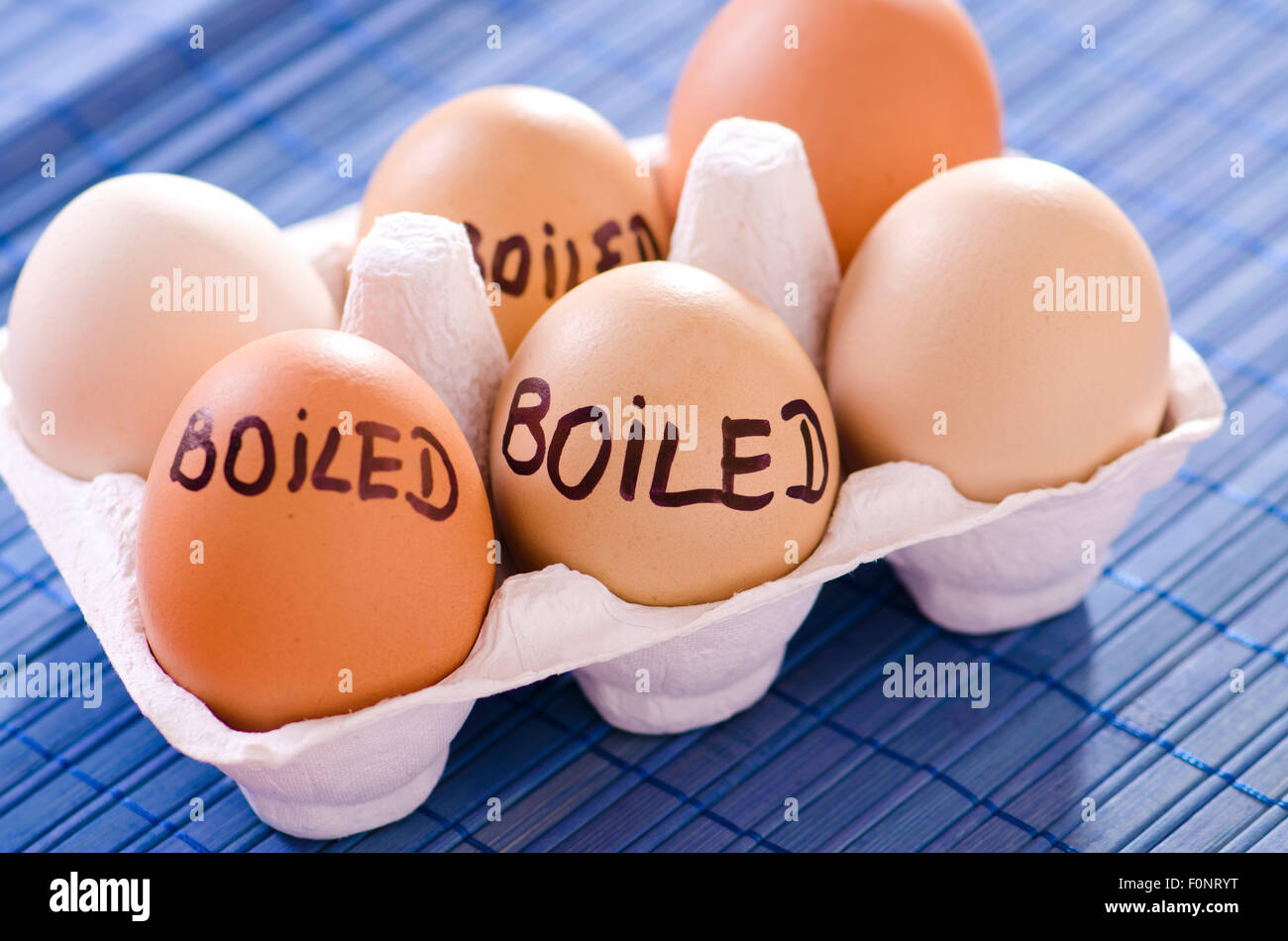 Boiled eggs in the paper pack on the table over blue mat Stock Photo ...