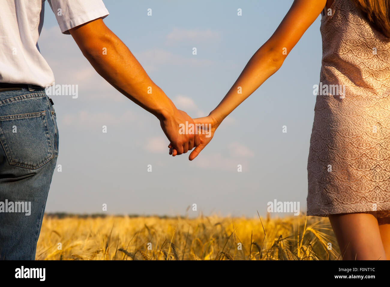 hands of couple of lovers in field on sky background Stock Photo - Alamy