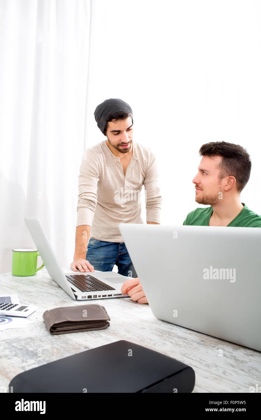 Two young colleagues discussing something in the office Stock Photo - Alamy