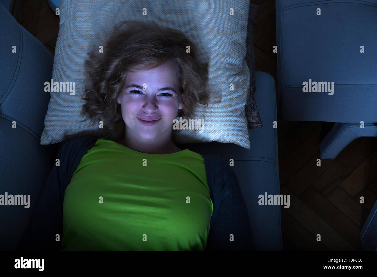 A young plus size woman lying on the sofa at night Stock Photo - Alamy