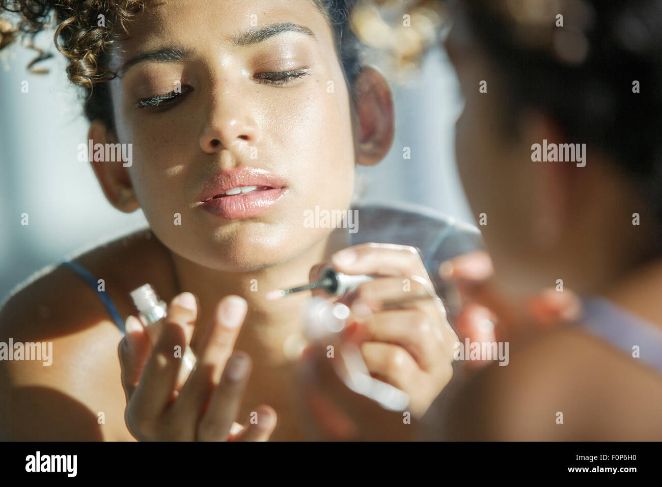 Young beautiful woman checking makeup in front of a mirror Stock Photo ...