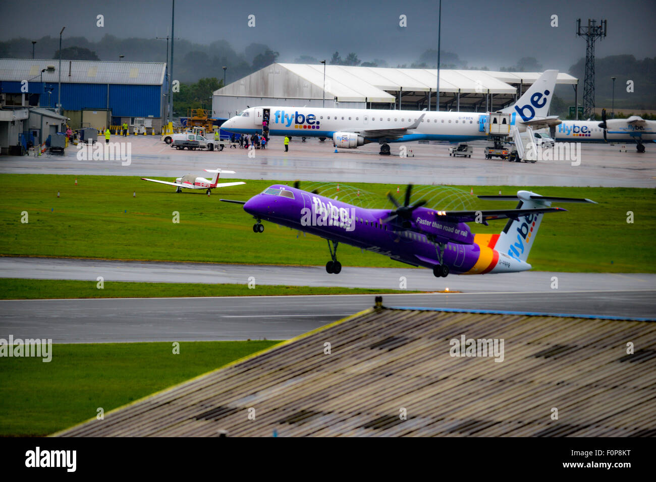 FlyBe Jet Taxing during wet Summers weather at Exeter Airport Stock ...