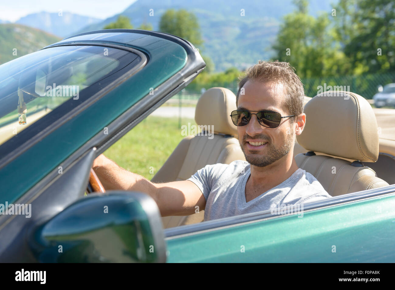 a smiling young man in a green convertible Stock Photo - Alamy