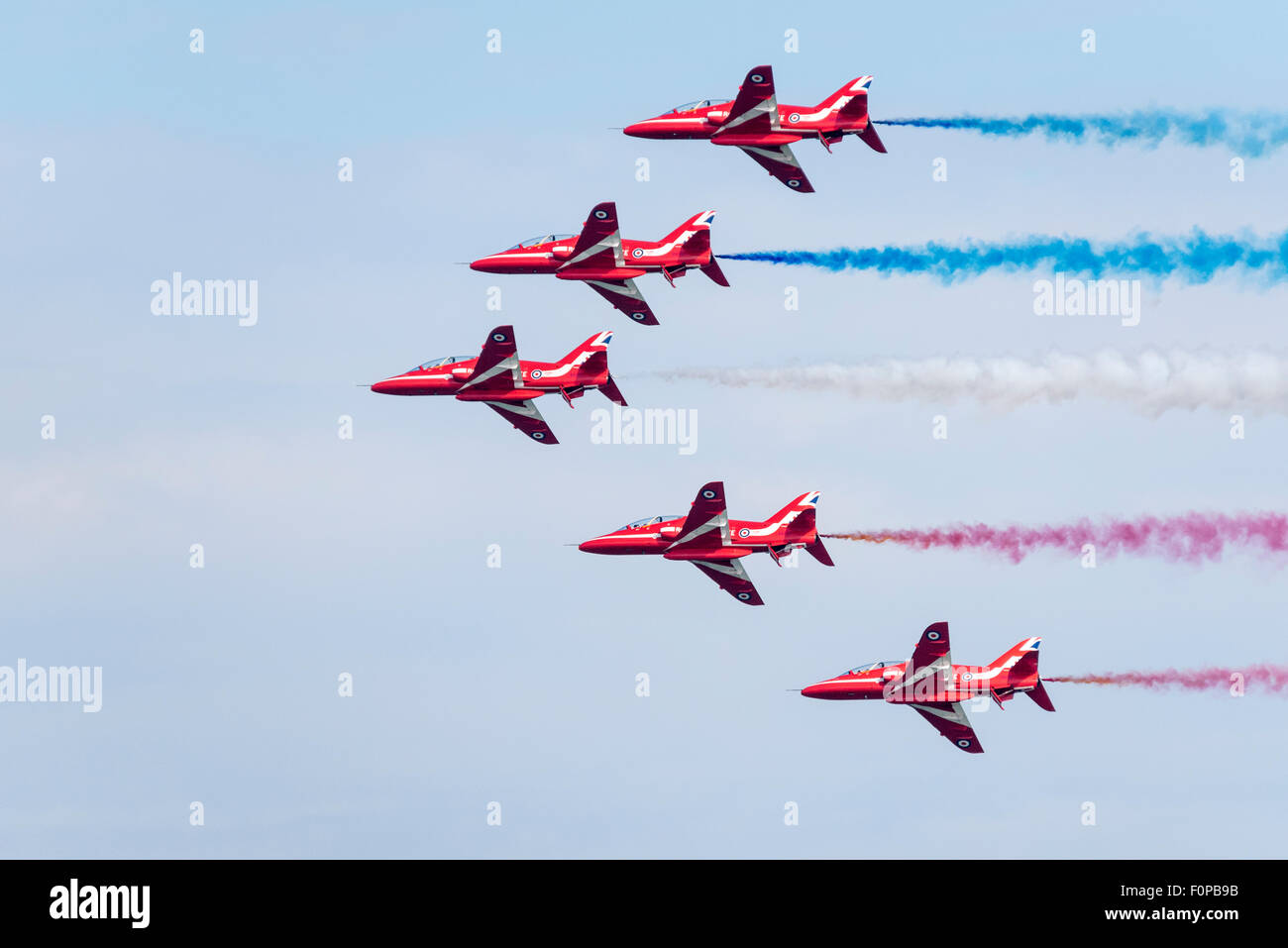 Five Red Arrows in formation and releasing coloured red, white and blue ...
