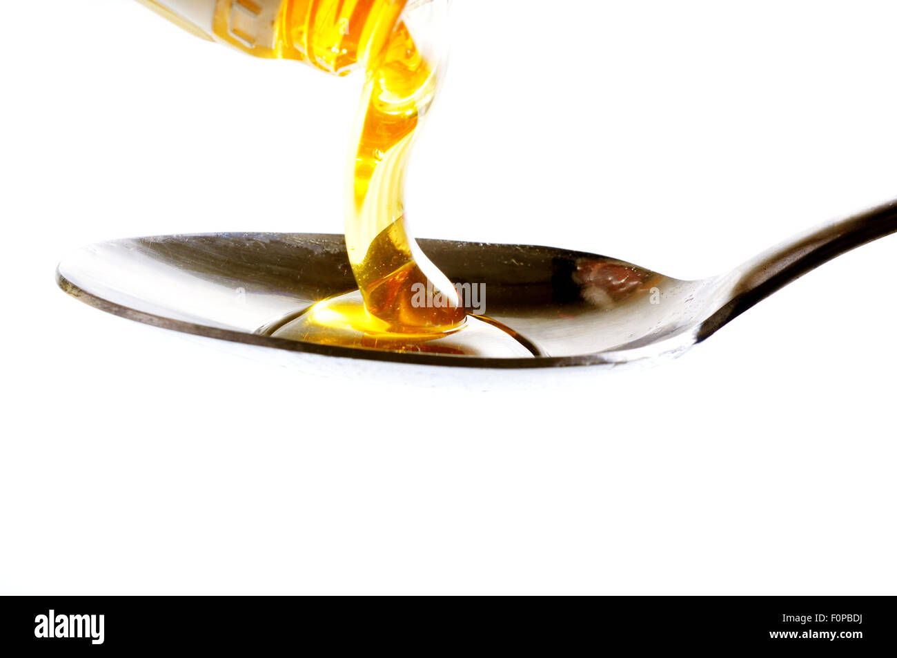 Honey falling on a spoon isolated on a white background Stock Photo - Alamy