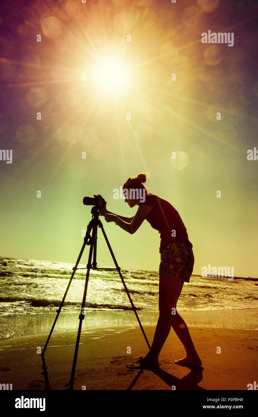 Pretty woman is a professional photographer with dslr camera and tripod ...