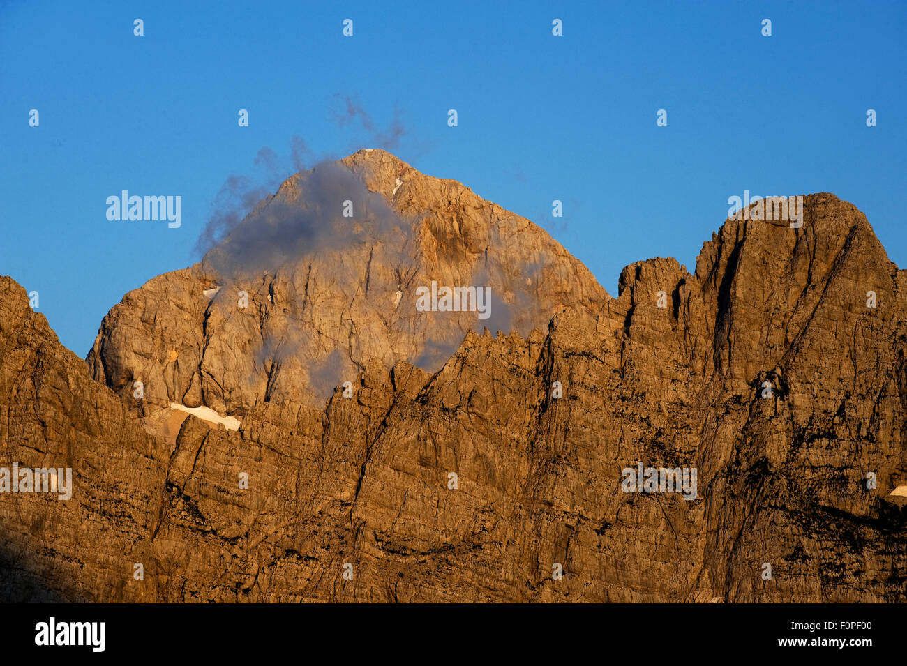 Peak of Mount Triglav (2,864m) with a small grey cloud in front of it ...