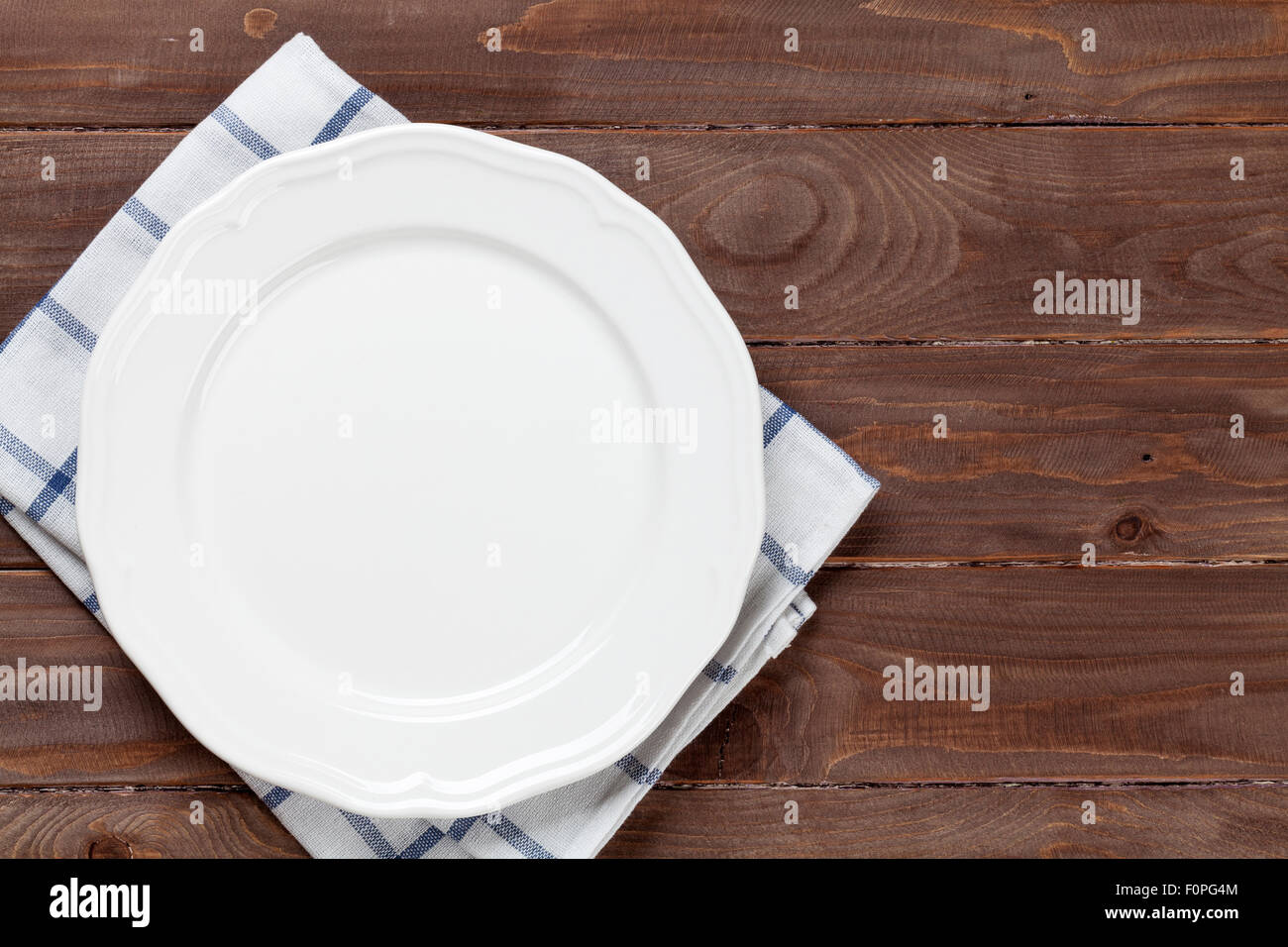 Empty plate over wooden table background. View from above with copy ...