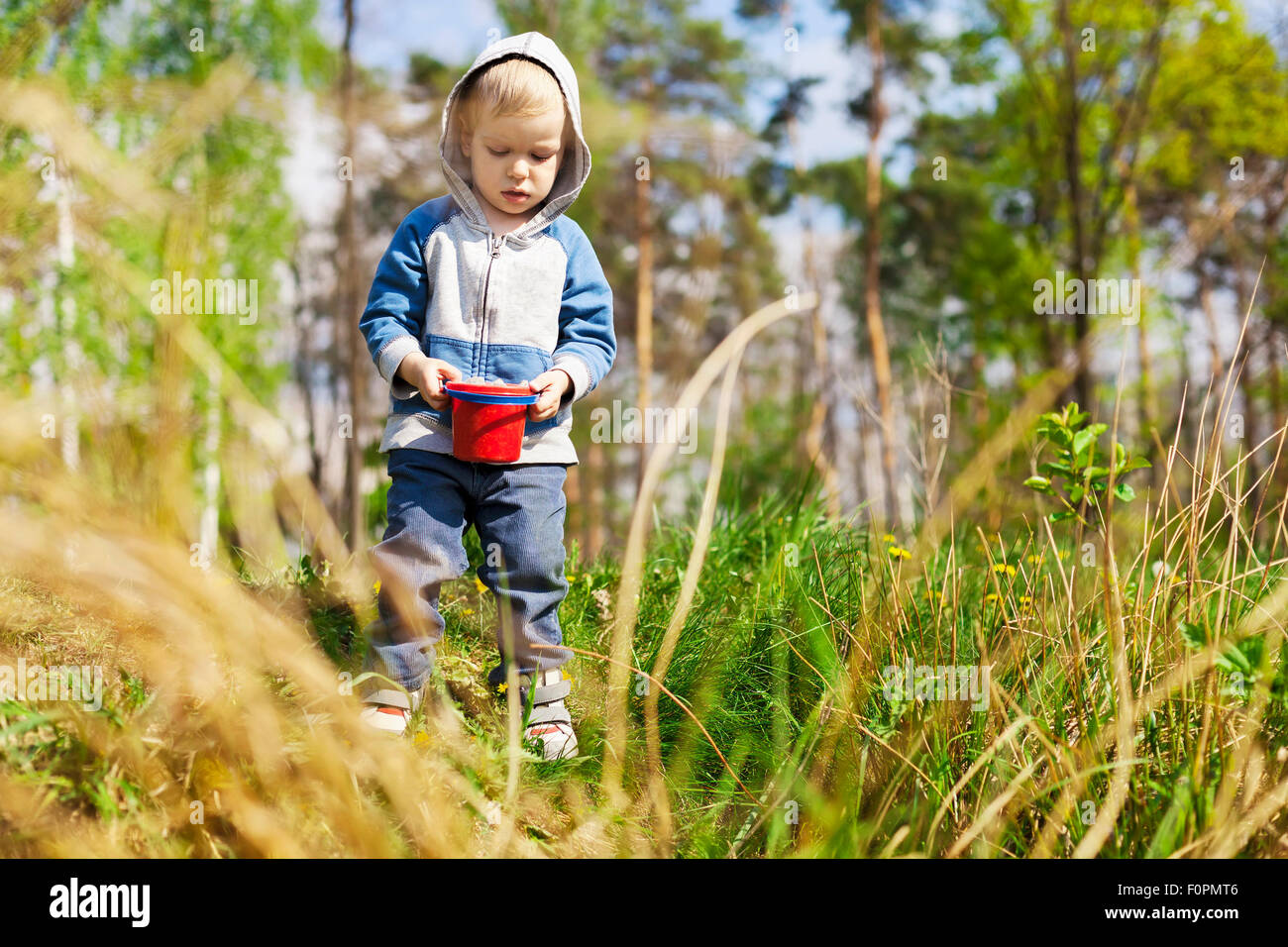 Little boy playing with toy bucket outdoors Stock Photo - Alamy