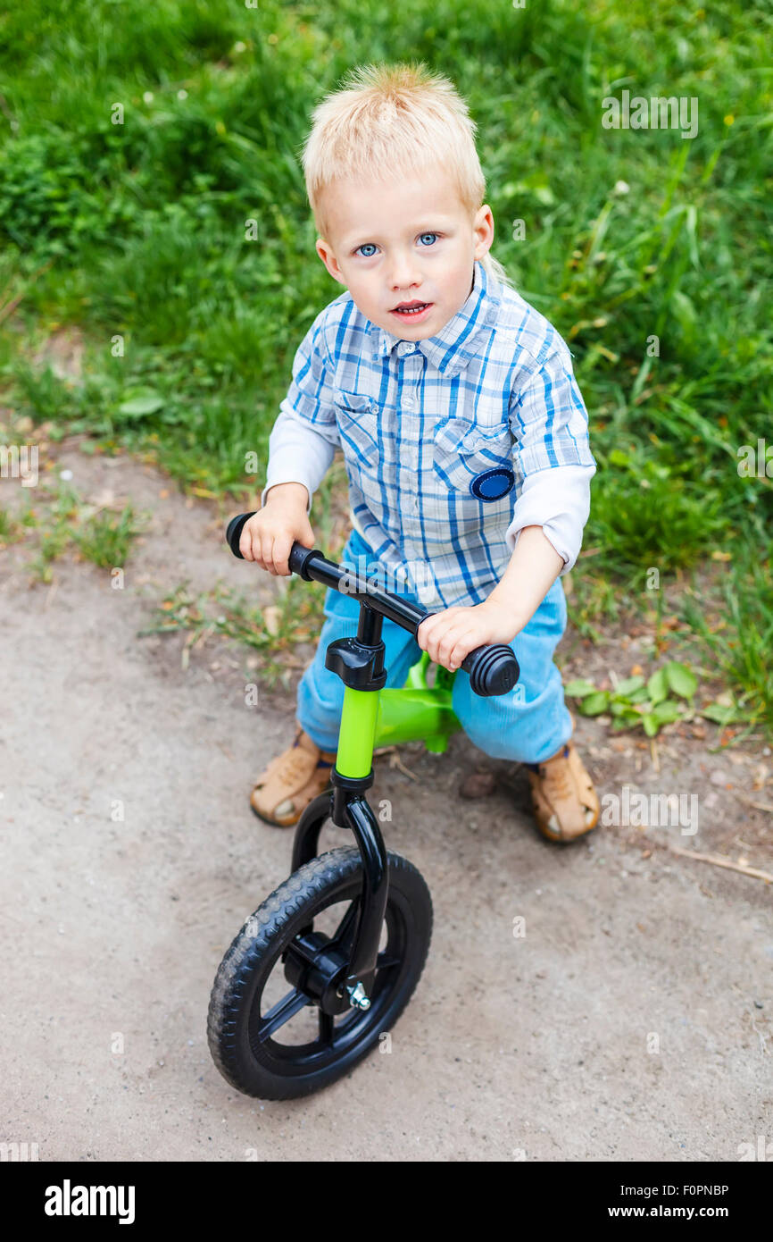 Happy little boy riding learner bike Stock Photo - Alamy