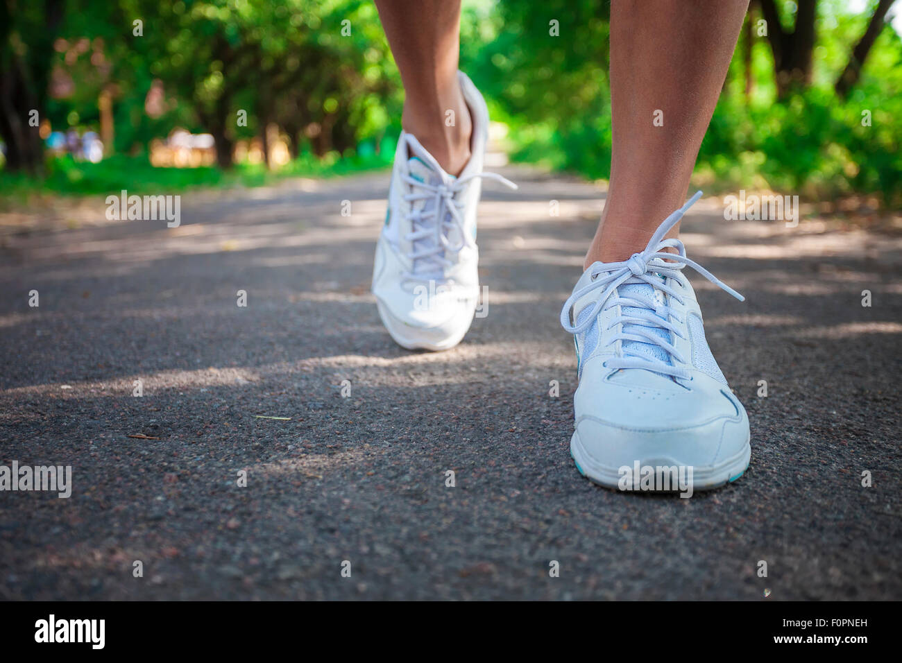 Cropped view of woman athlete running on pathway in park Stock Photo ...