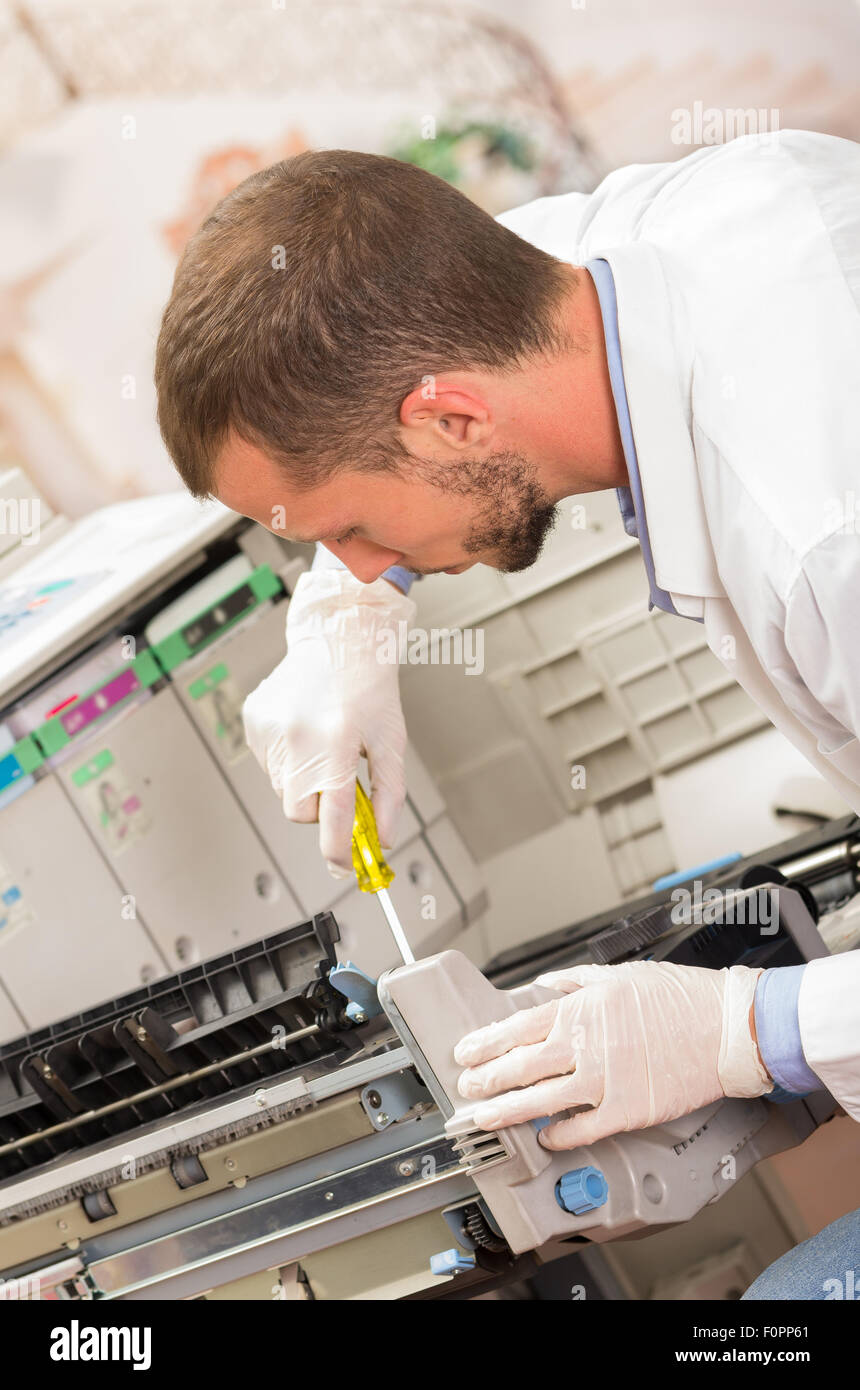 closeup shot young male technician repairing digital photocopier ...