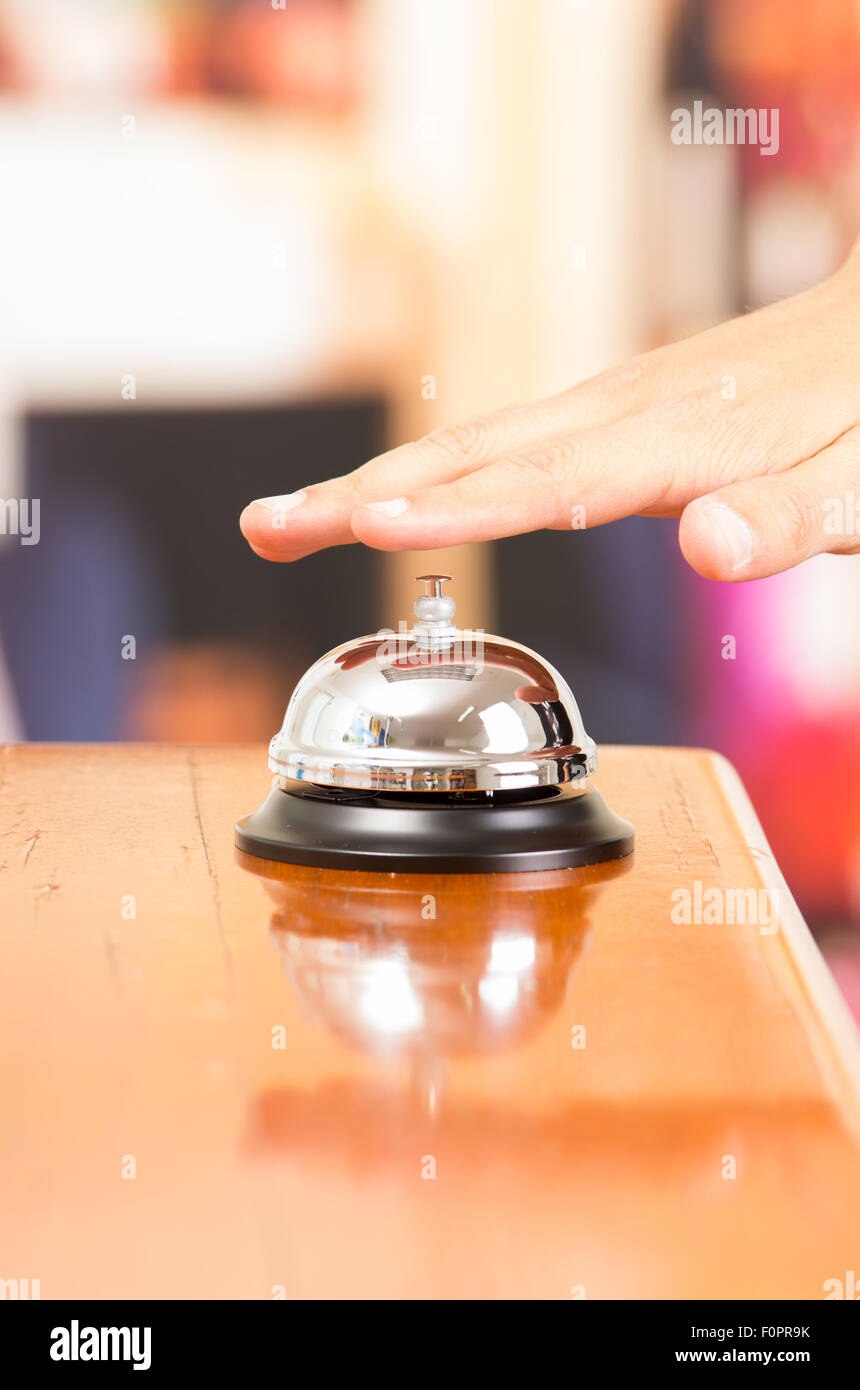 hand ringing hotel bell in reception desk close up selective focus ...