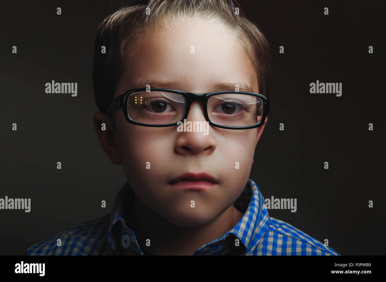 Low key closeup portrait of little boy looking sad Stock Photo - Alamy