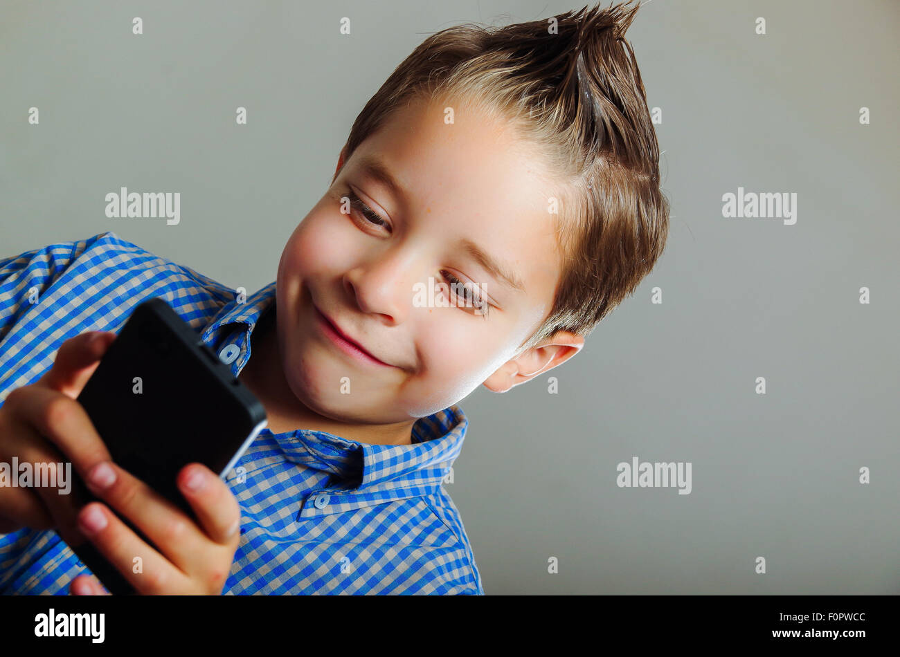 Cute boy using cell phone Stock Photo - Alamy