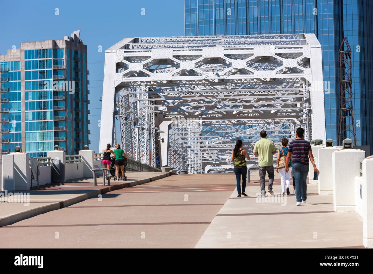 People walk across the John Seigenthaler pedestrian bridge into ...