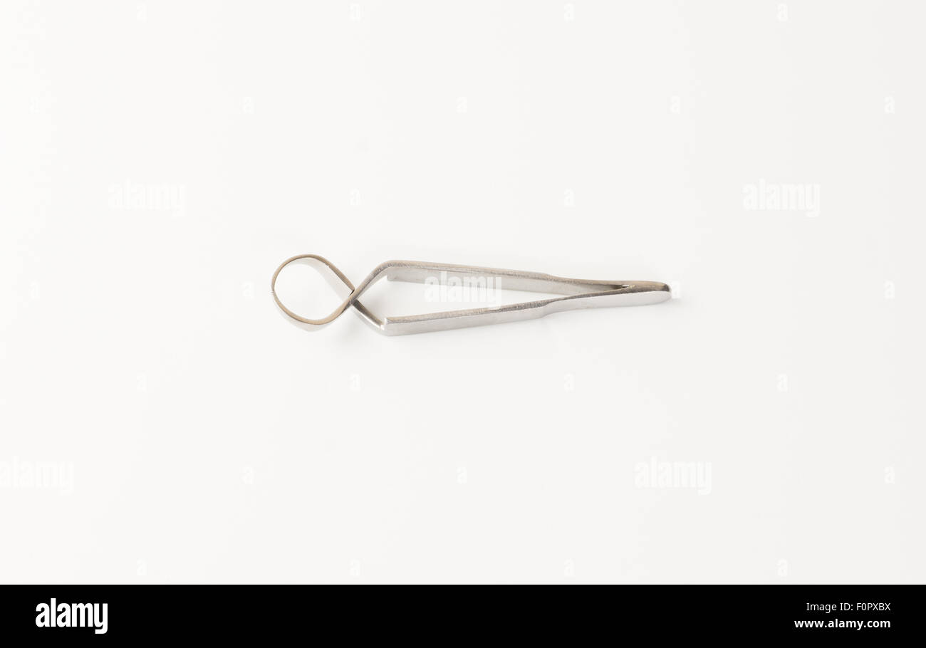 some chrome medical surgical tools lie on a white background Stock ...