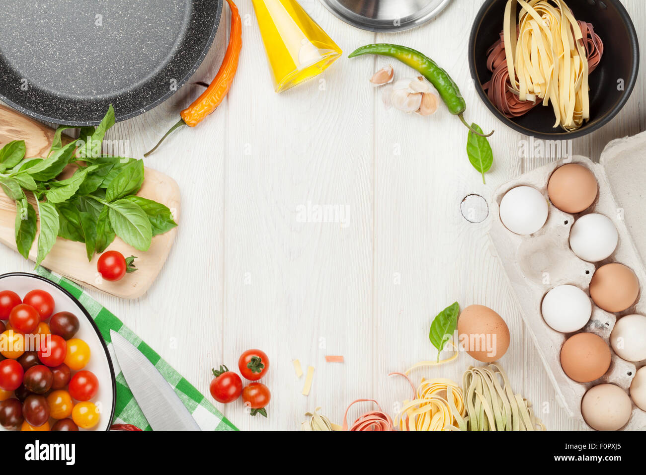 Pasta cooking ingredients and utensils on wooden table. Top view with ...
