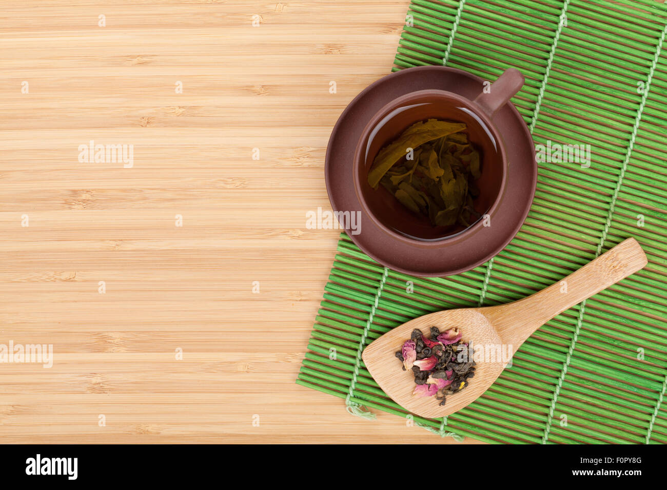 Japanese green tea and sakura branch over bamboo table with copy space ...