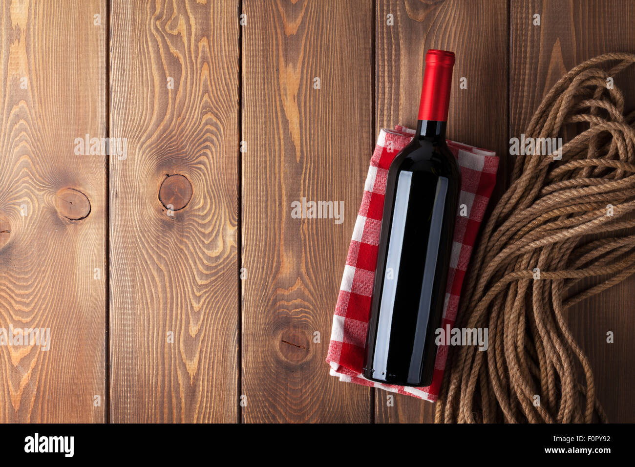 Red wine bottle over rustic wooden table background with copy space ...