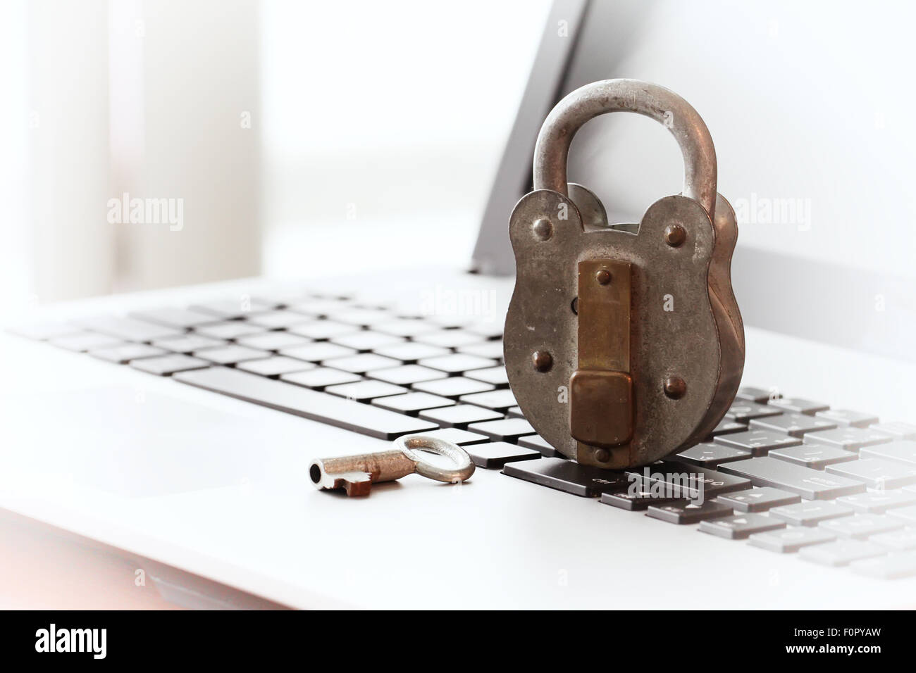 Internet security concept-old padlock and key on laptop computer ...