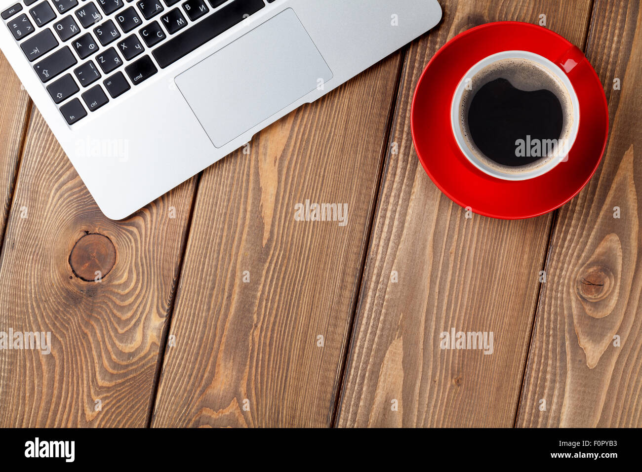 Office desk table with laptop computer and coffee cup. Top view with ...