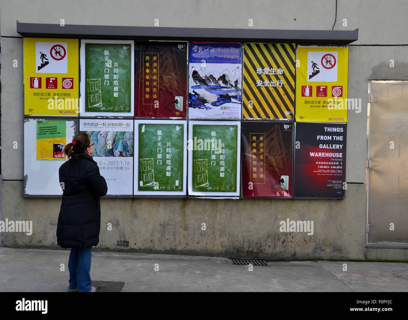 Woman looks at exhibition posters at M50 arts district Shanghai China ...