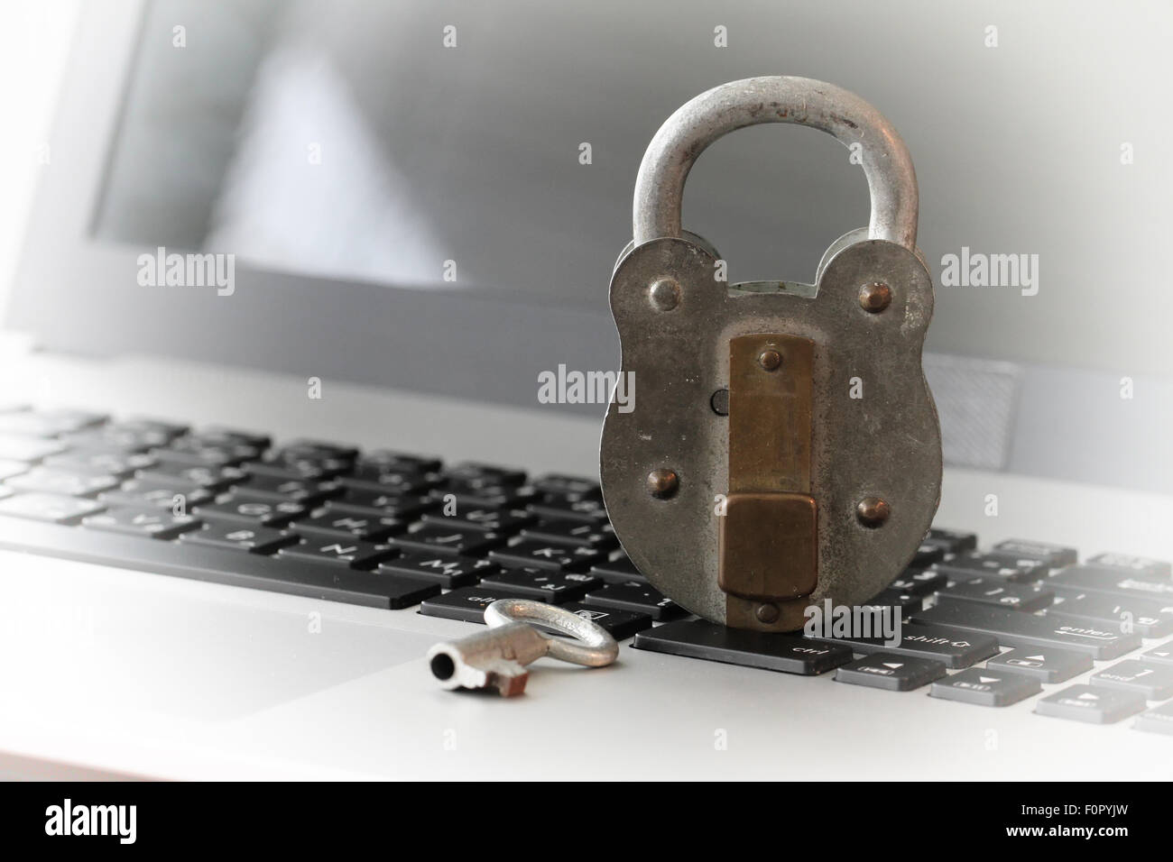 Internet security concept-old padlock and key on laptop computer ...