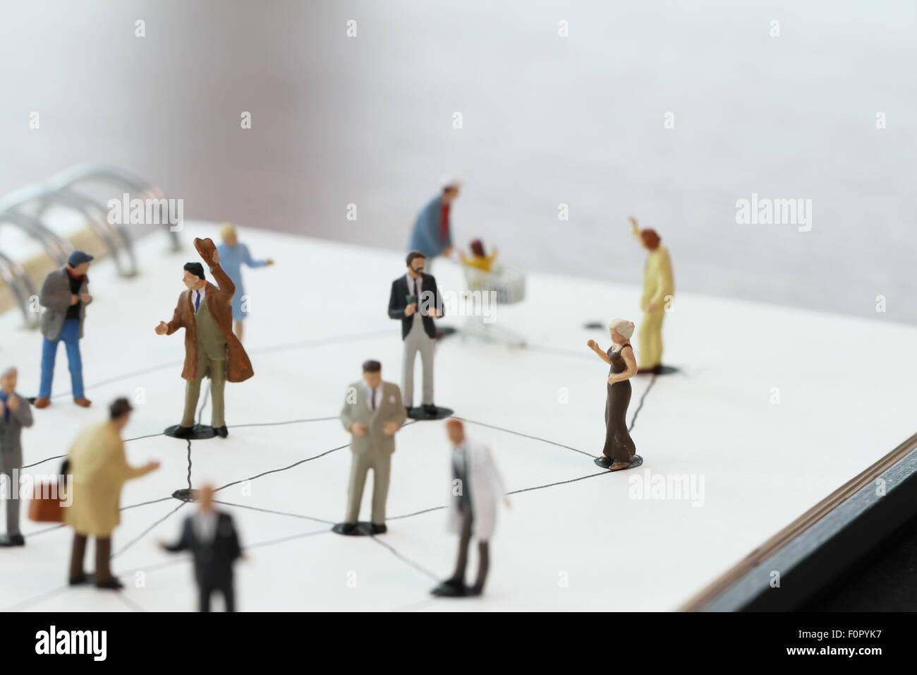 close up of miniature people with social network diagram on open ...