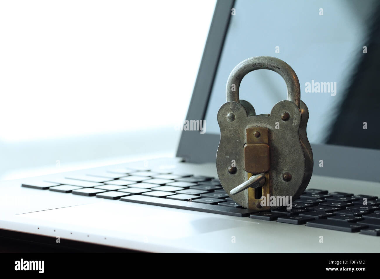 Internet security concept-old padlock and key on laptop computer ...