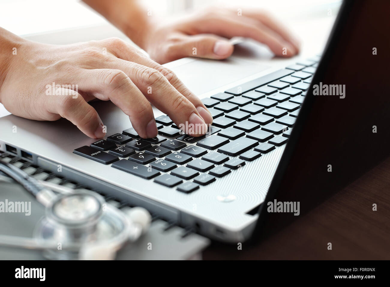 Doctor working with laptop computer in medical workspace office as ...