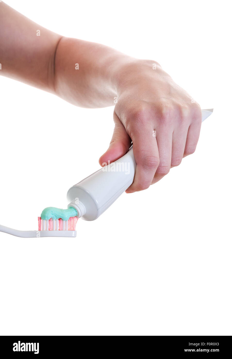 Female hand applying Toothpaste to tooth brush isolated over white with ...