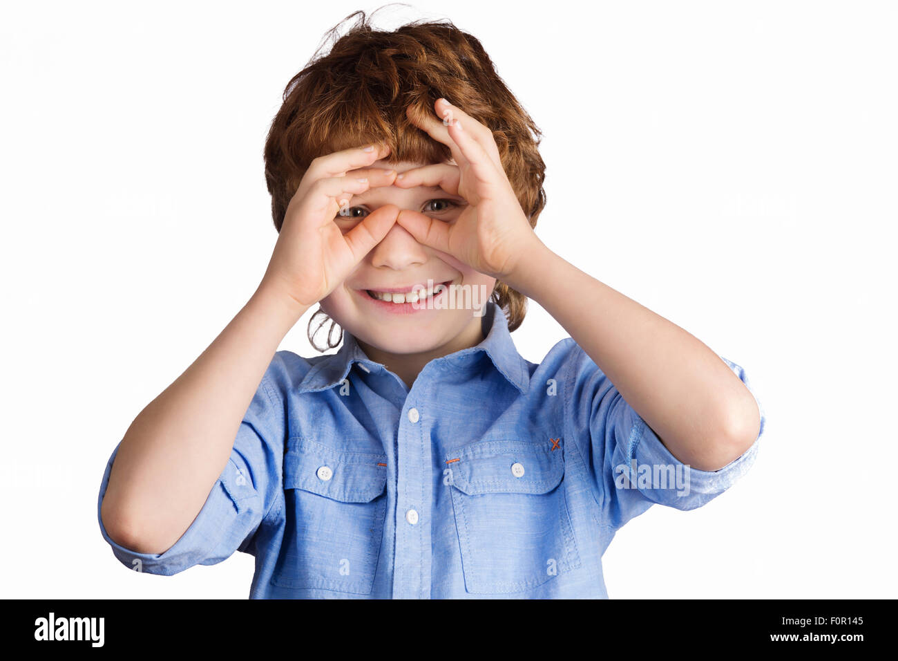 Handsome smiling boy makes aviator glasses with his hands. Isolated on ...
