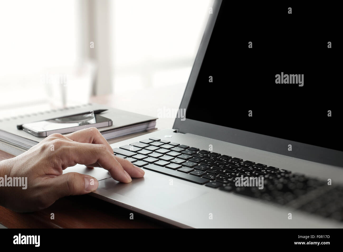 Close up of business man hand working on blank screen laptop computer ...