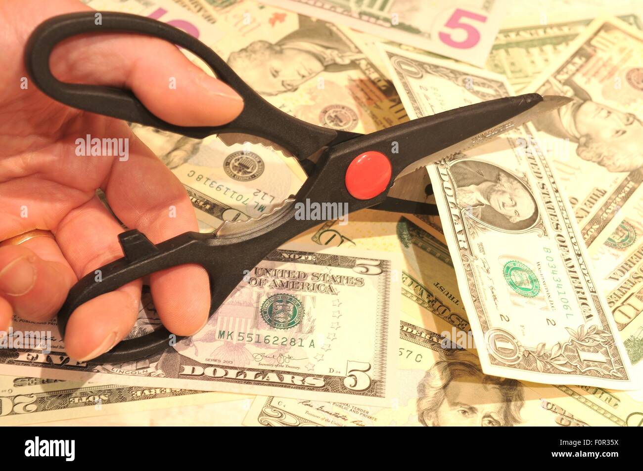 Budget cut concept with scissors and US dollars Stock Photo - Alamy