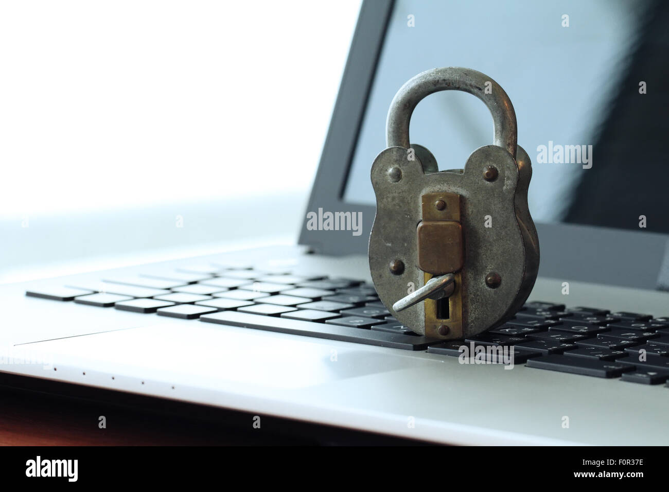 Internet security concept-old padlock and key on laptop computer ...