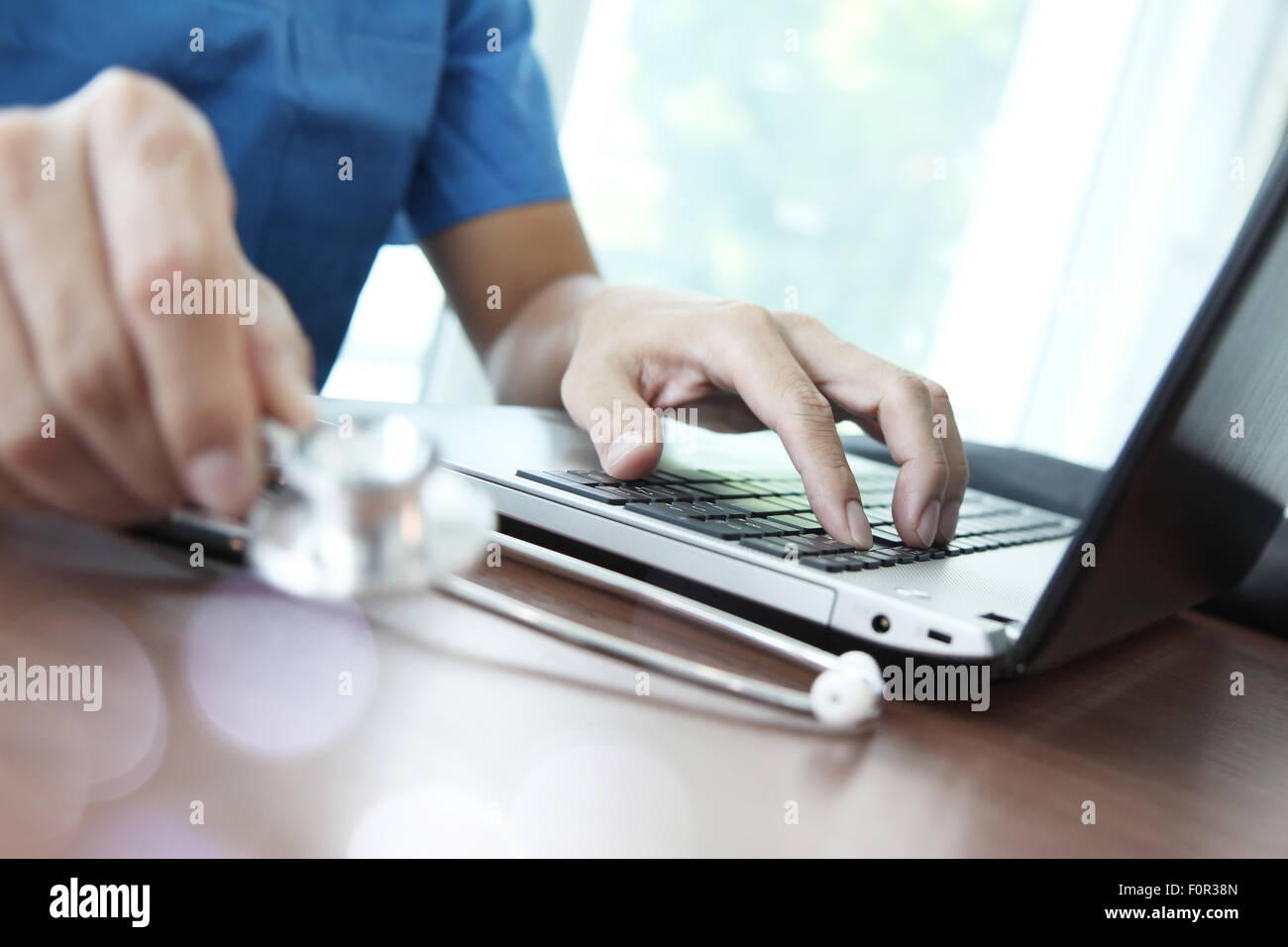 Doctor working with laptop computer in medical workspace office as ...