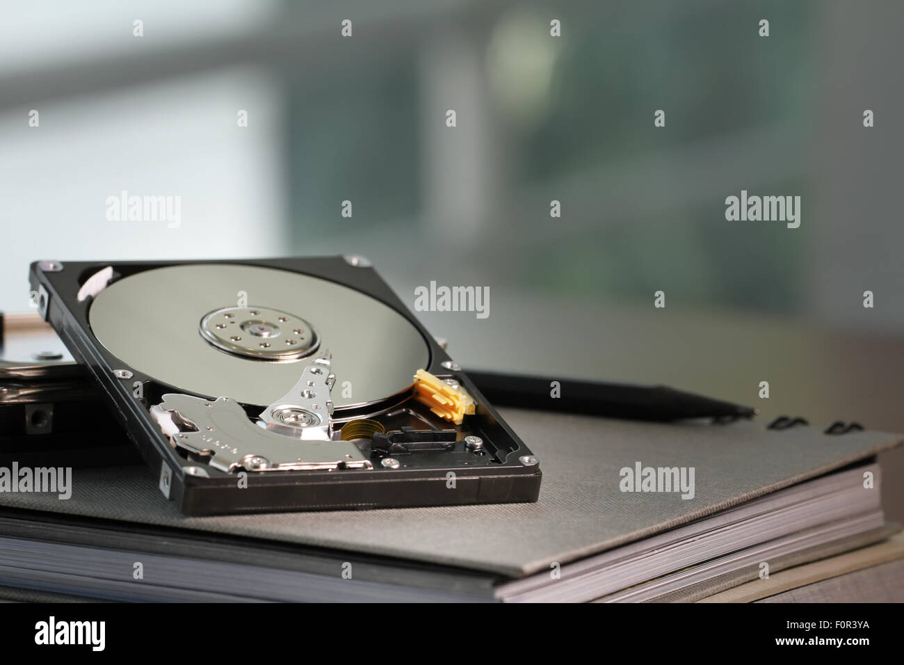 Close up of open computer hard disk drive on desk and notebook Stock ...
