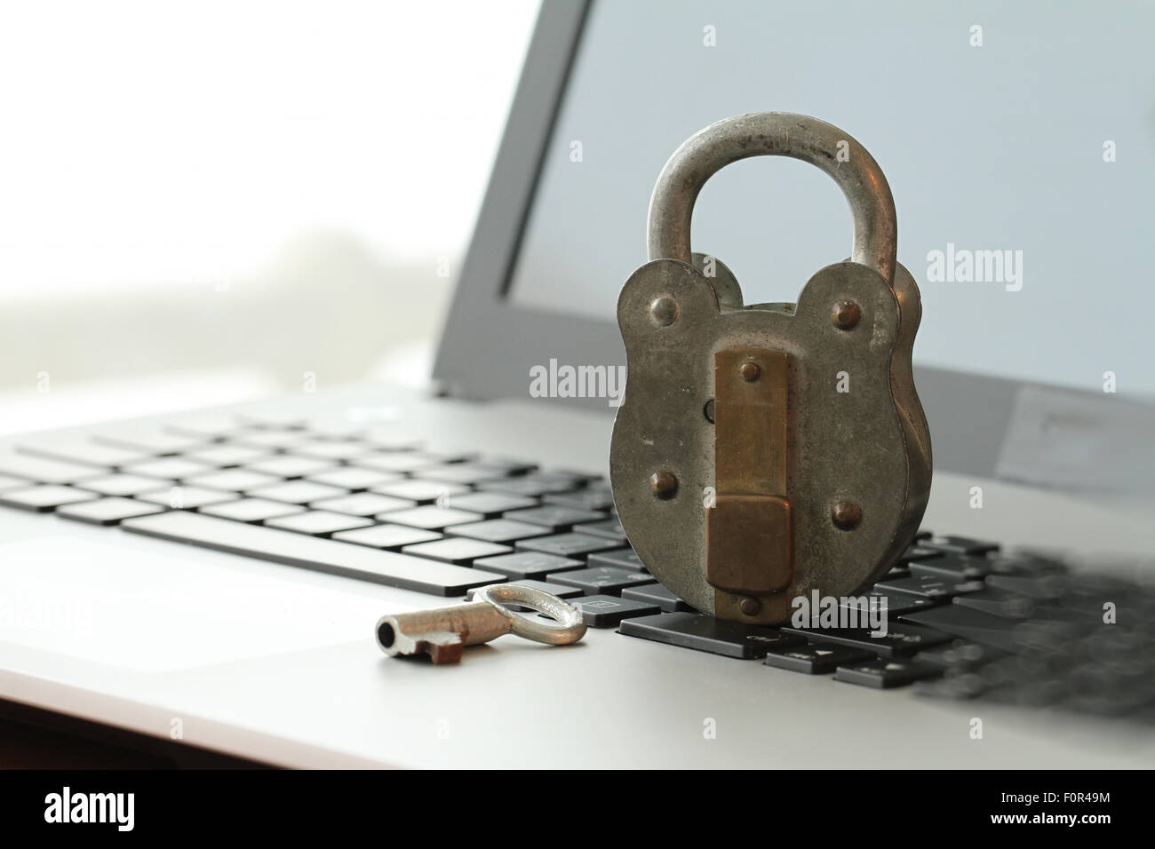 Internet security concept-old padlock and key on laptop computer ...