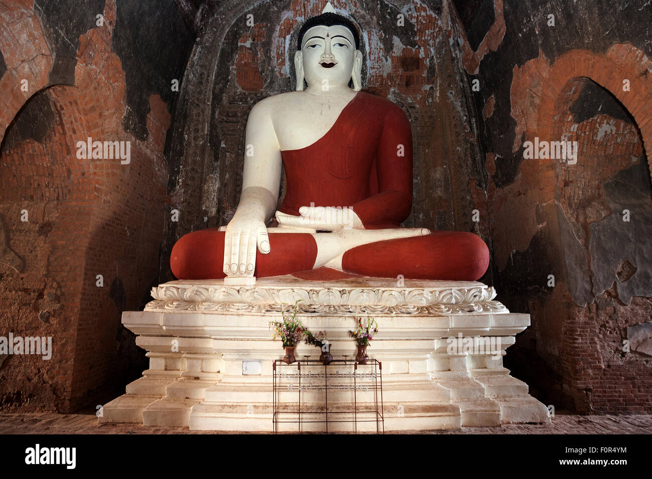 Seated Buddha with red robe, stone statue, Ananda Temple, Bagan ...