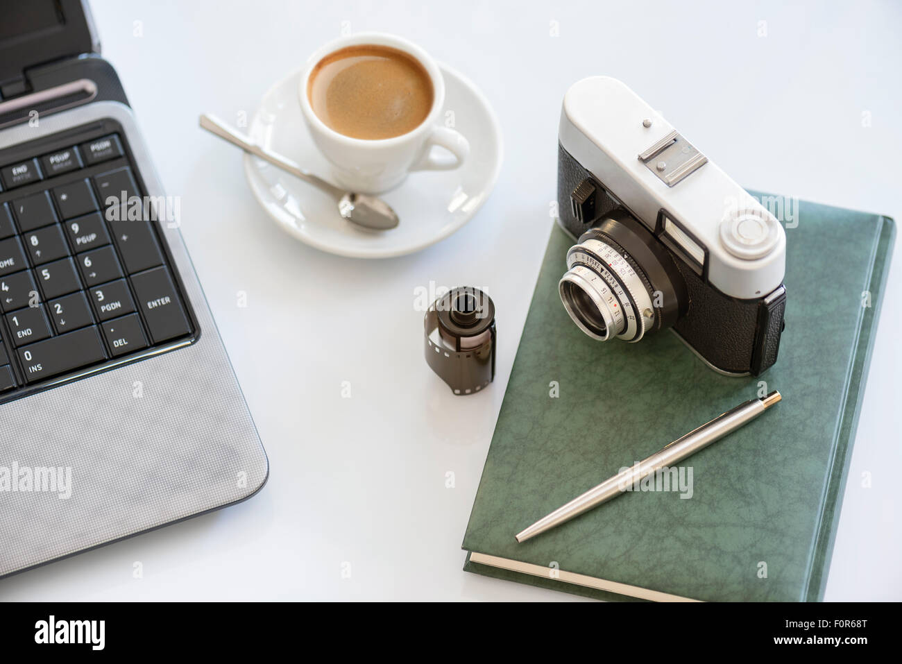 35mm vintage photocamera on diary with film, cup of coffee pen and ...