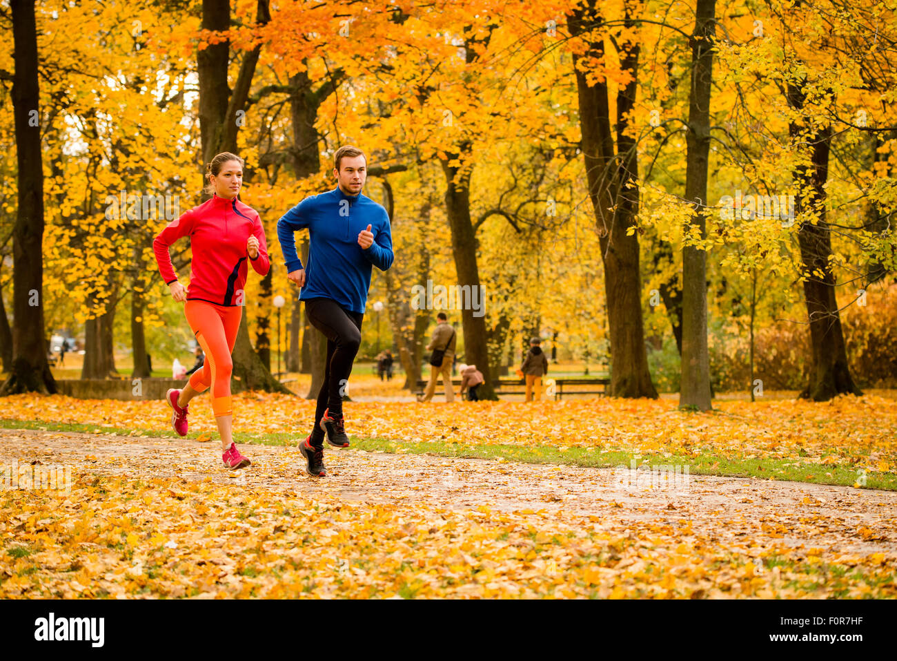 Young couple jogging together in park - autumn season Stock Photo - Alamy