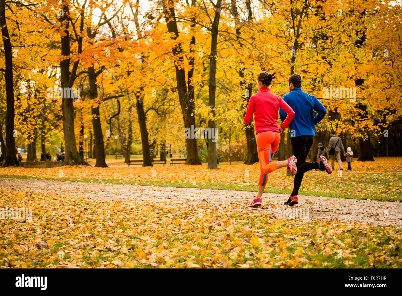 Young couple running together in park - fall nature Stock Photo - Alamy