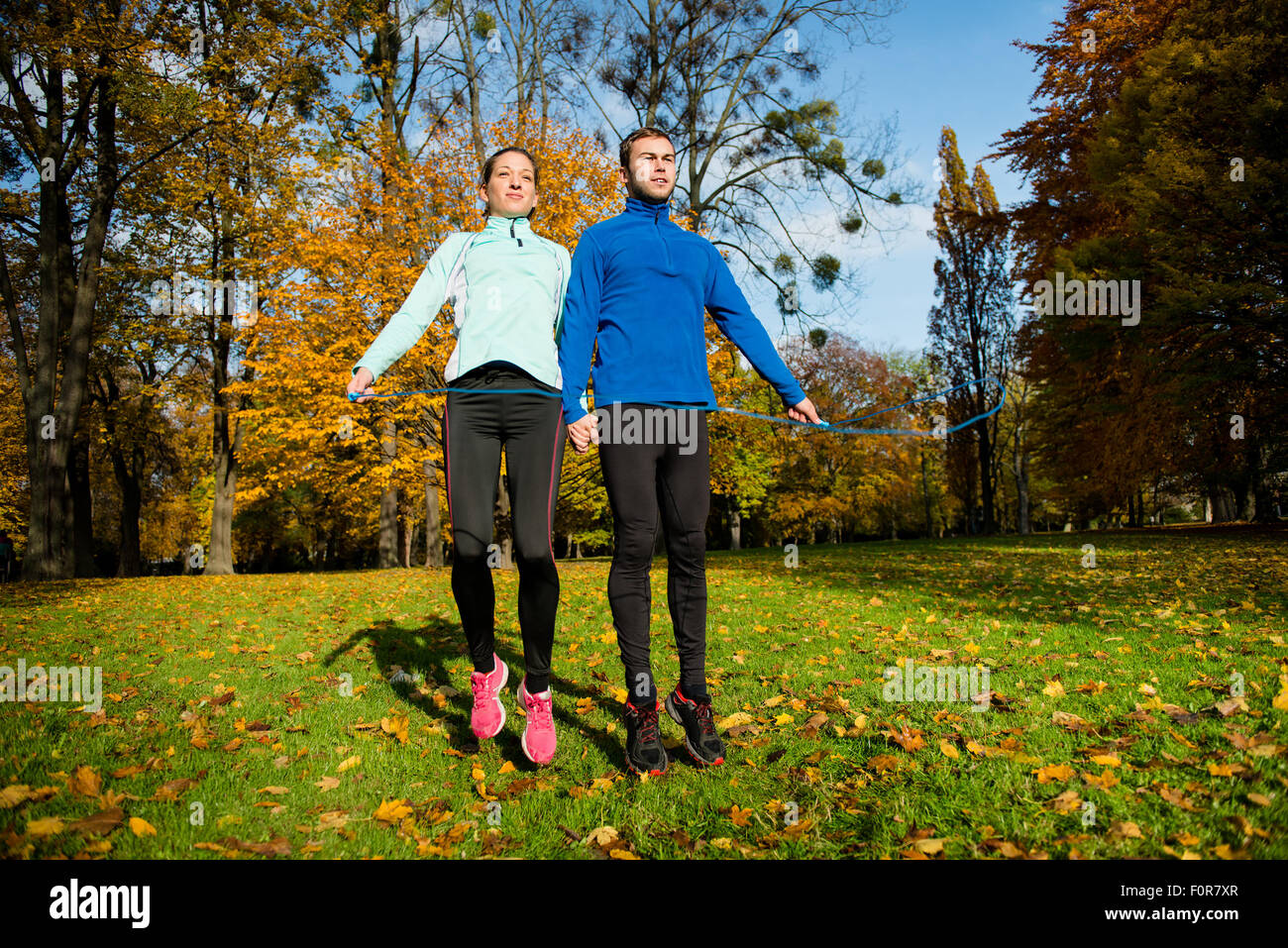 Workout - young couple jumping together with skipping rope Stock Photo ...