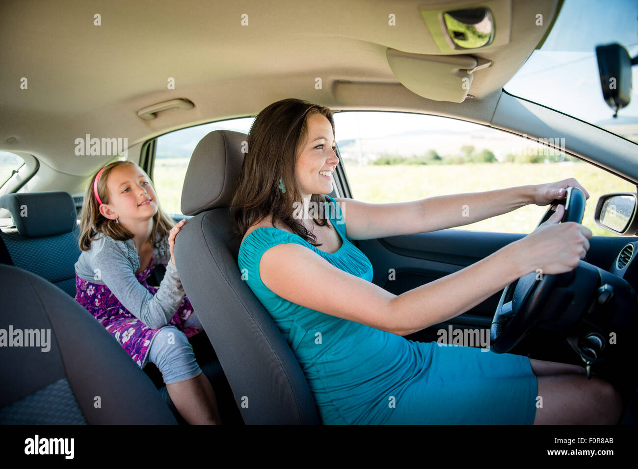 Mother driving car and child sitting on back seat - no belt, dangerous ...