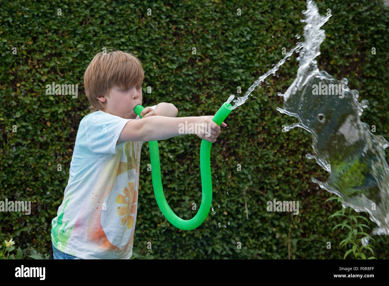 young boy splashing water with hose Stock Photo - Alamy