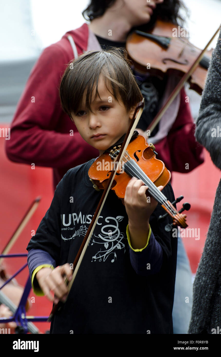 Young boy violinist playing with a youth string orchestra at the ...