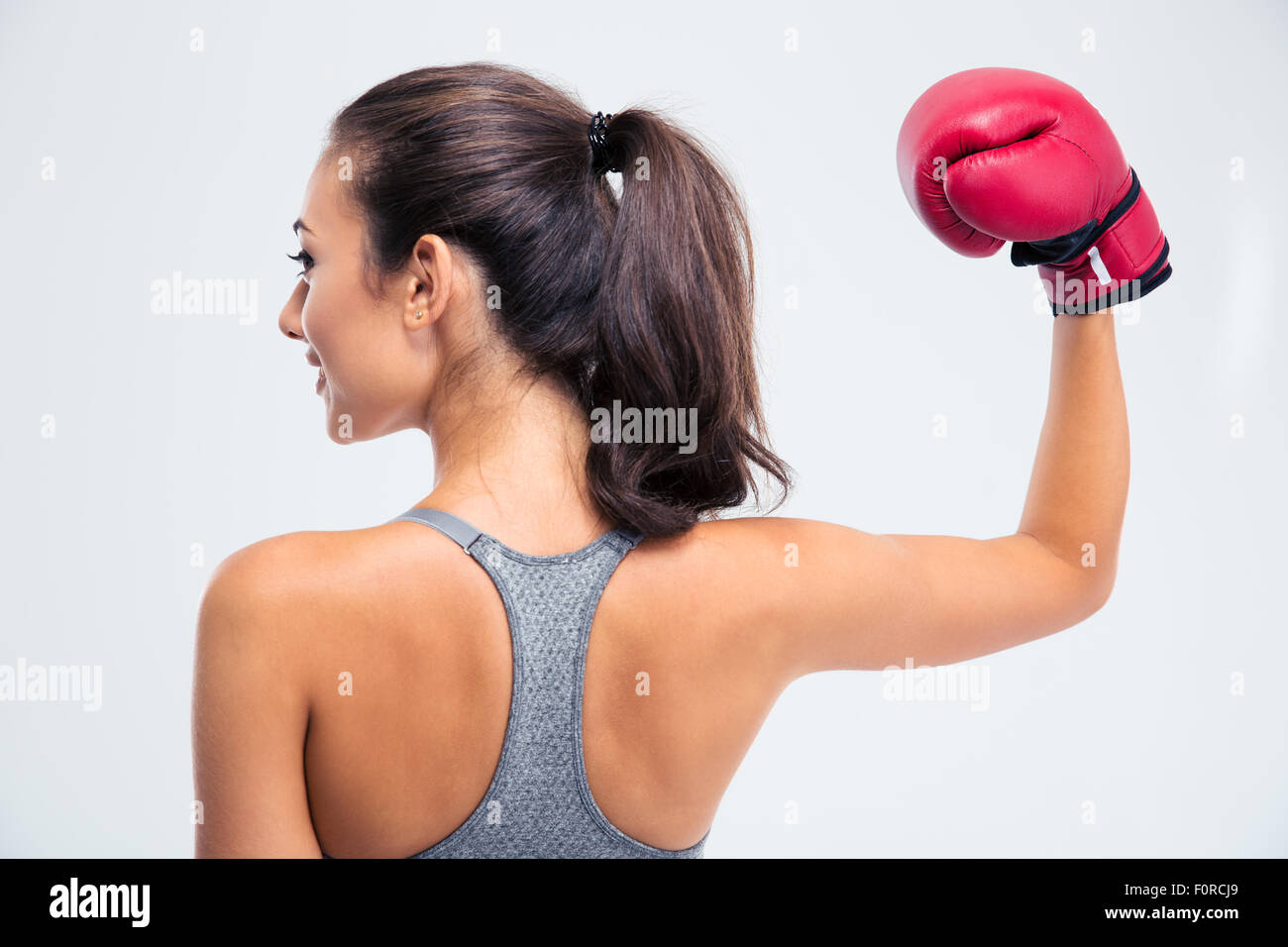 Back view portrait of a sports woman standing with boxing gloves in ...